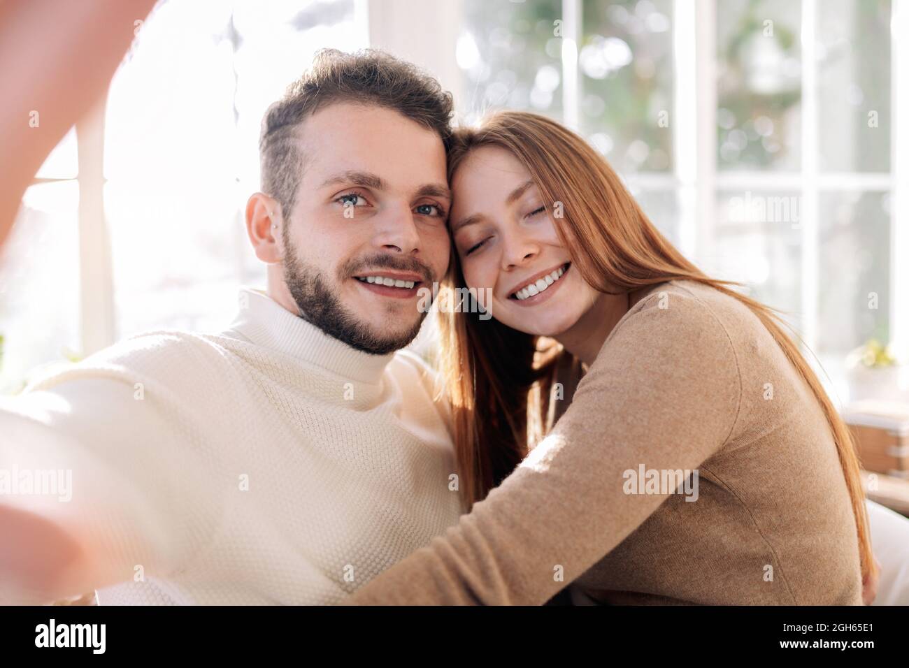 Cheerful bearded man with sincere female beloved taking self portrait ...