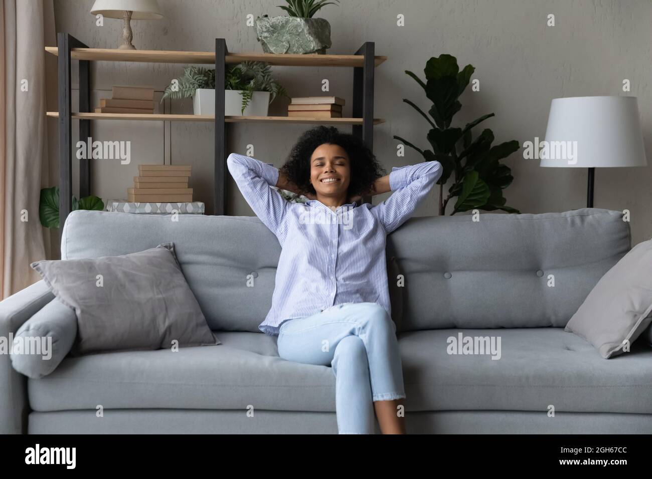 Tranquil teenage black female chill on comfy couch at home Stock Photo ...