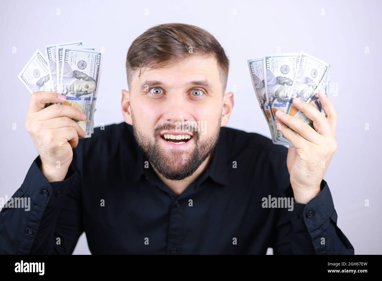 the businessman raised up his hands, in which he holds bills and ...