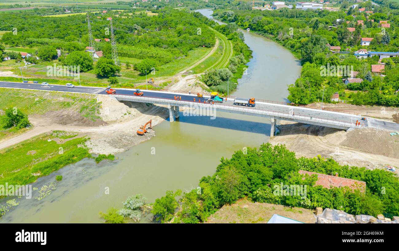 Above view, sideways, on workers and machinery for laying asphalt ...