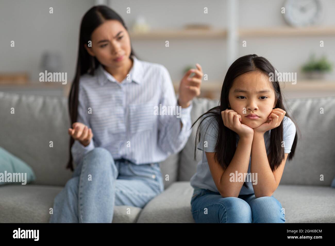 Family misunderstanding concept. Offended asian daughter sitting on ...