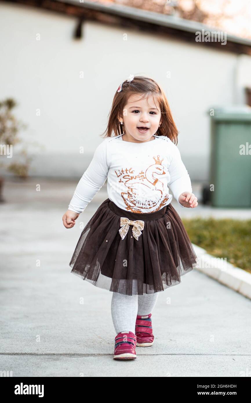 Cute, little toddler girl walking outdoors and smiling Stock Photo - Alamy