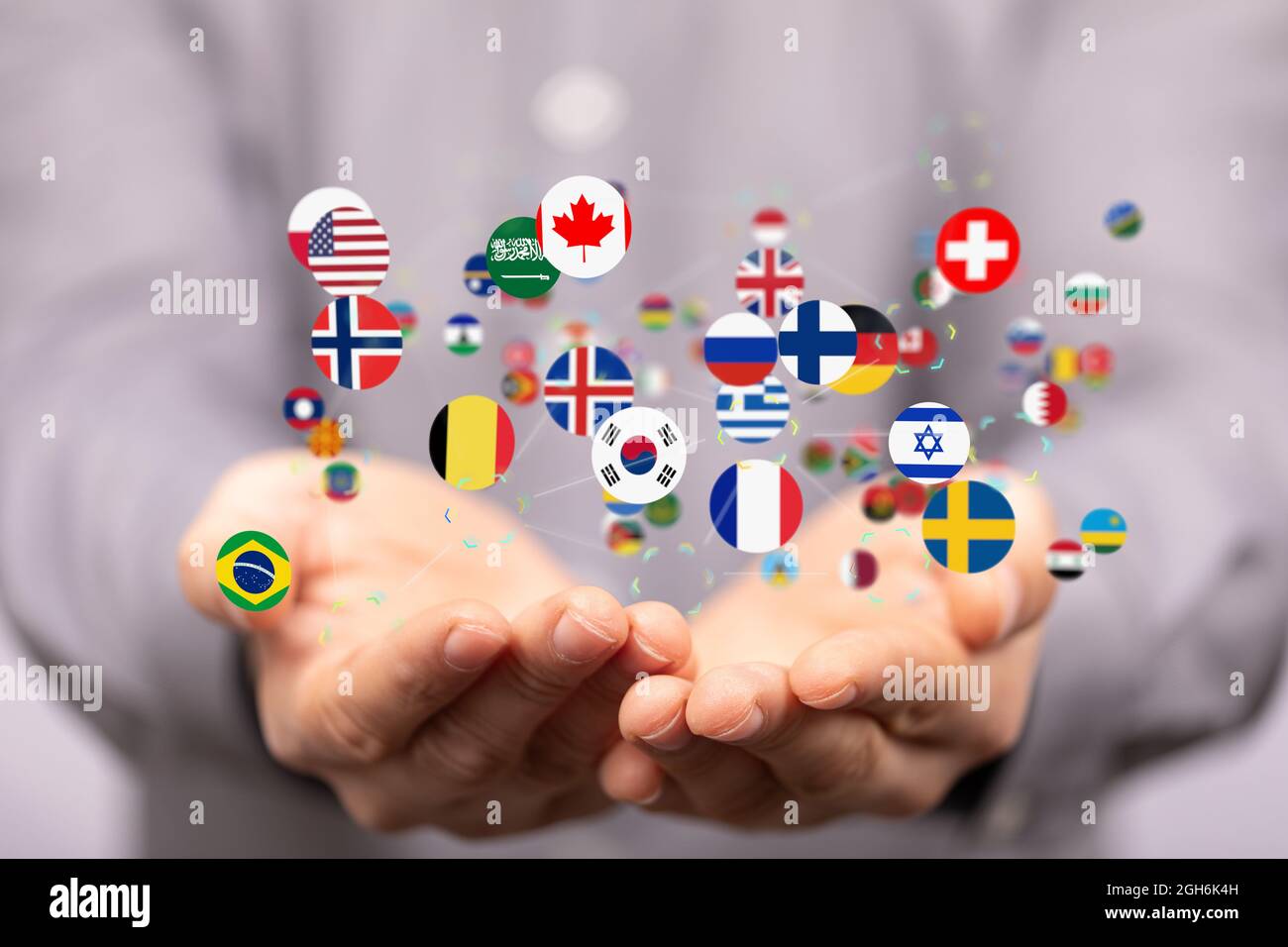 A hand holding icons of various flags - the concept of globalization ...