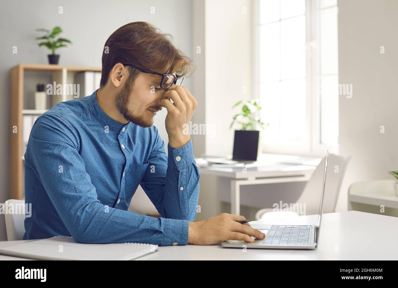 Stressed tired office worker has eye strain from constant work on ...