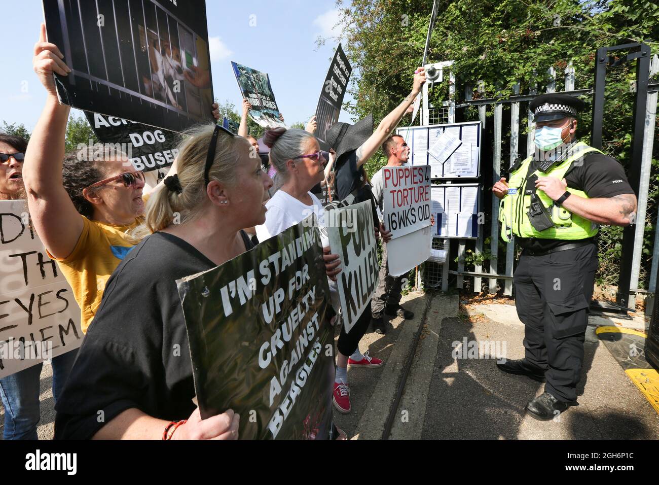Protesters hold up placards and chant slogans in front of a police ...