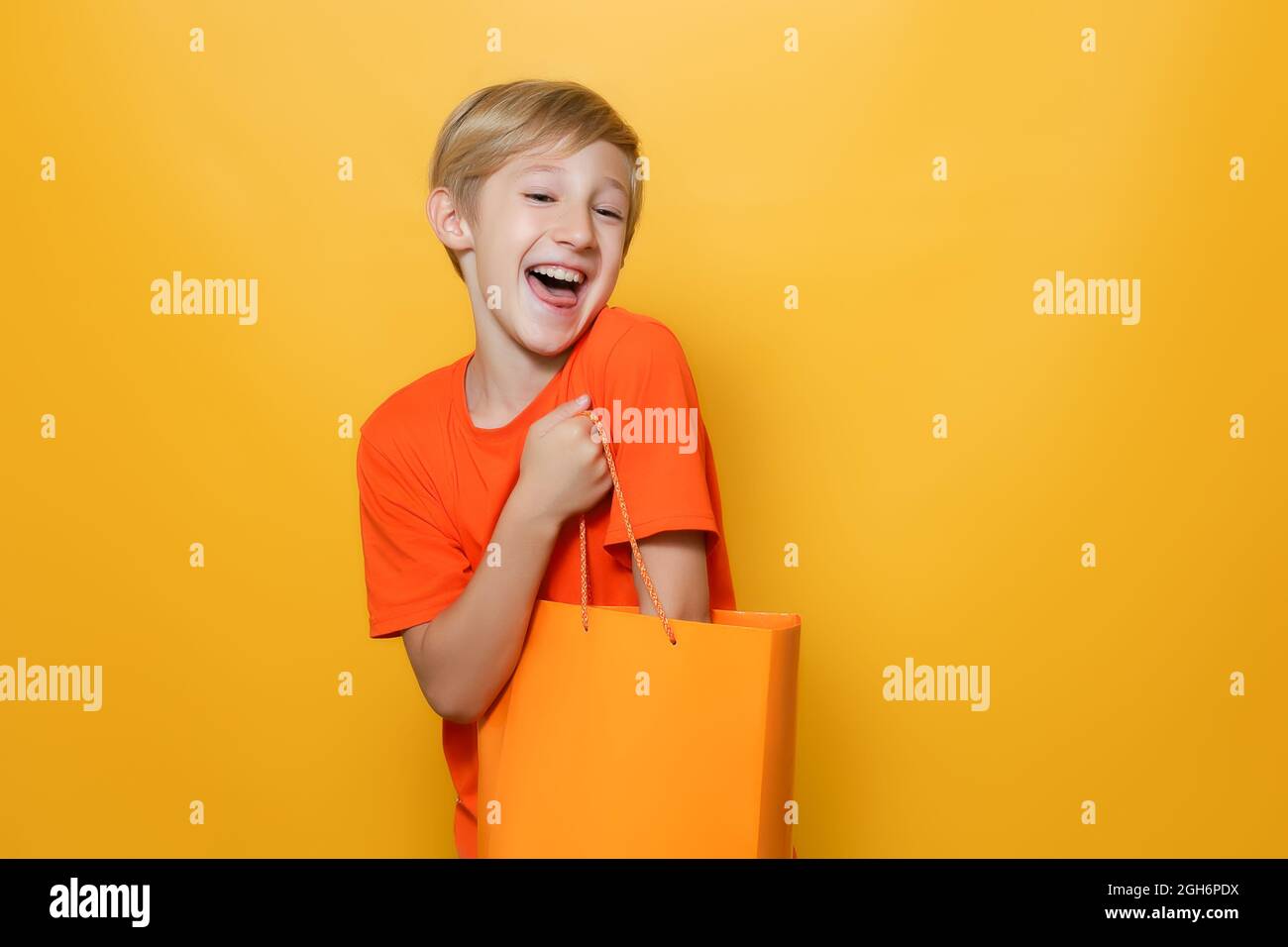 the boy has put his hand in an orange paper bag and is happy Stock ...