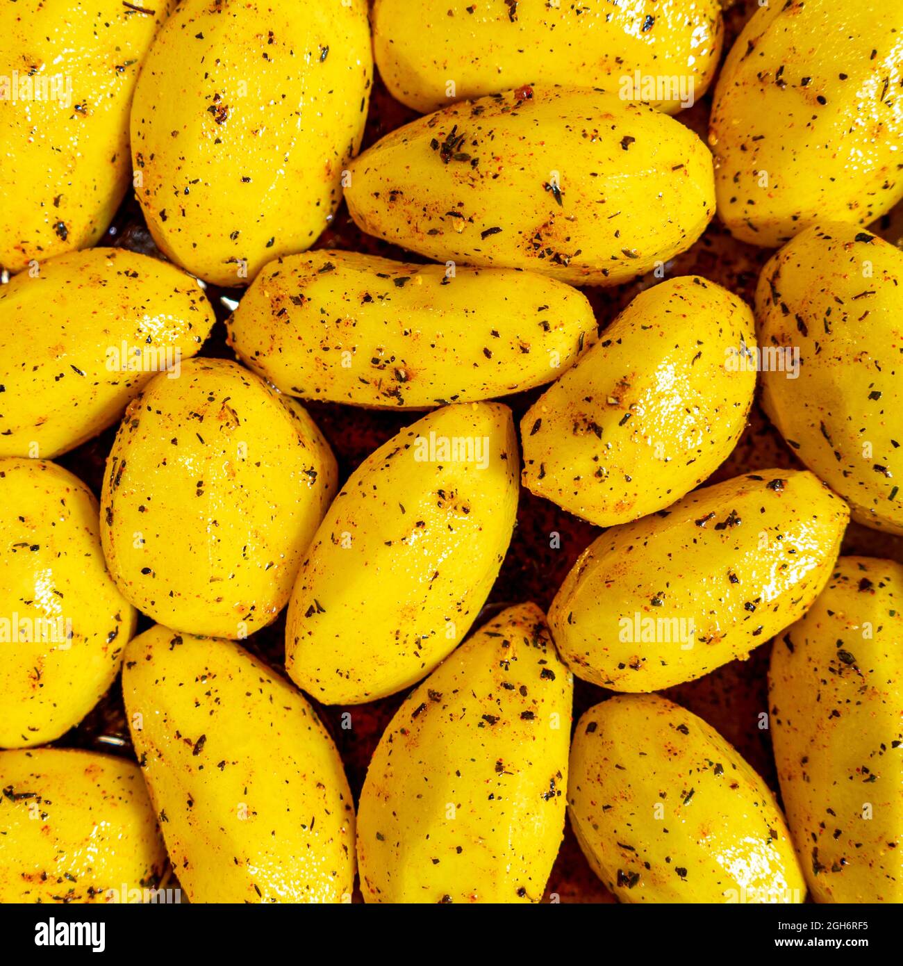 Raw potatoes with spices prepared for baking in oven Stock Photo - Alamy