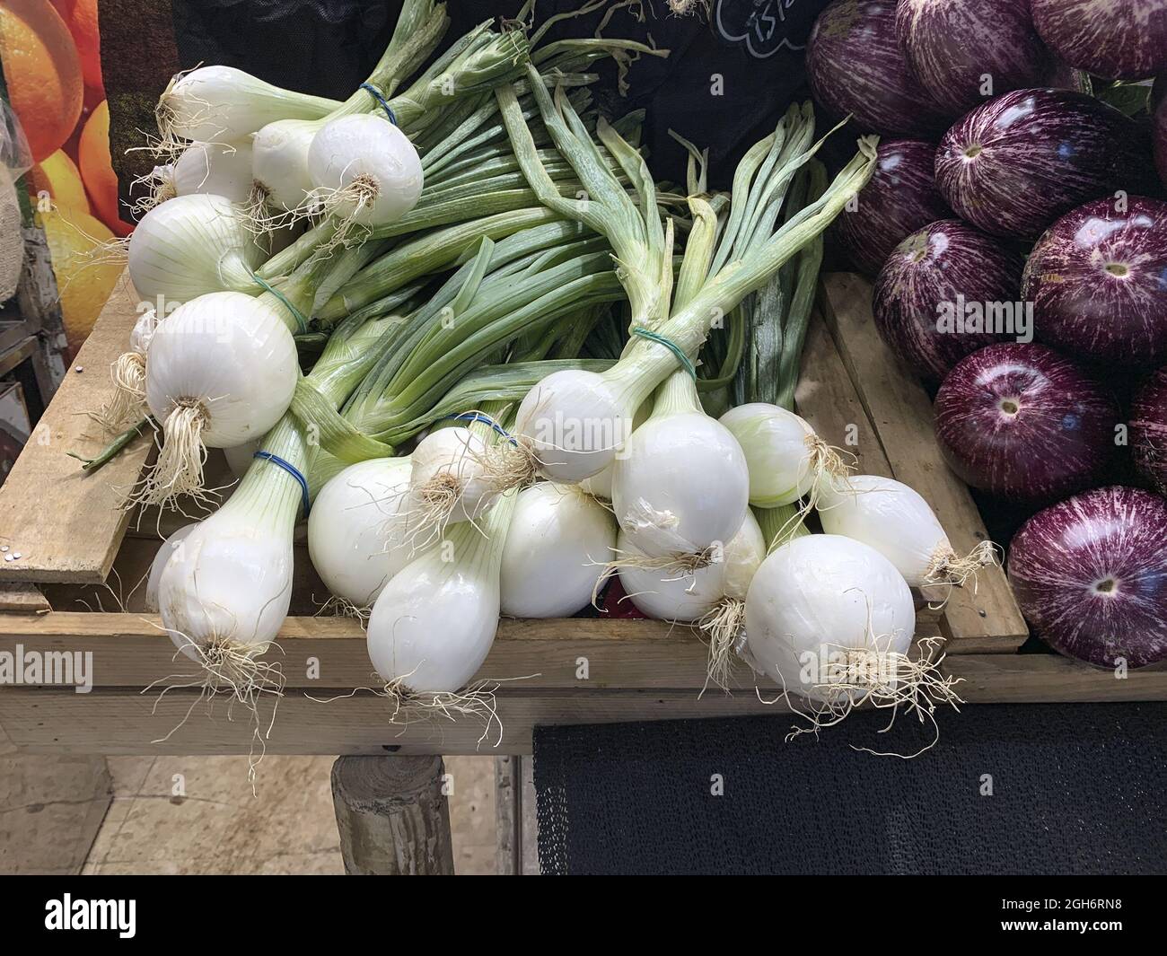 the Bunches of fresh white chives tied with a rubber band at a market ...