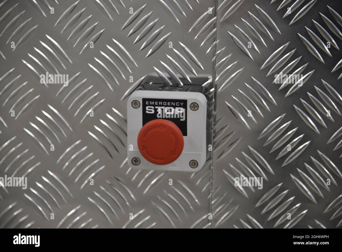 An Emergency stop red button installed on metal wall Stock Photo - Alamy