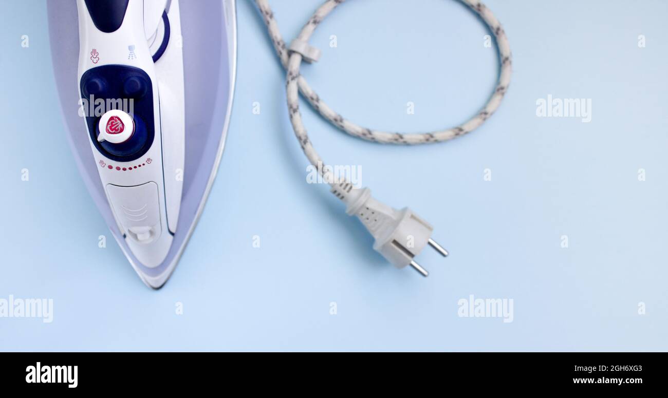 Iron for ironing things on a blue background. Top view, copy space ...