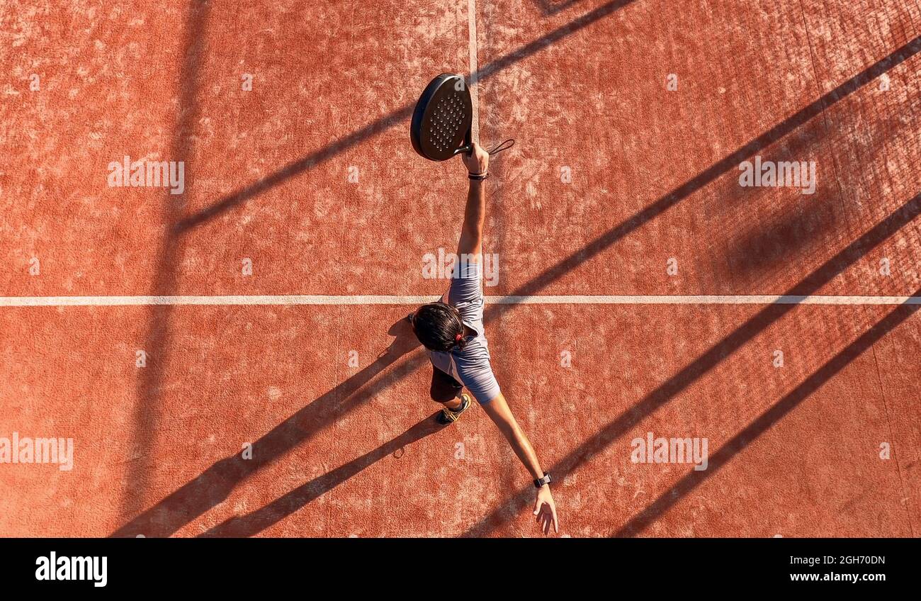 View from above of a man who is playing paddle tennis and has just hit ...