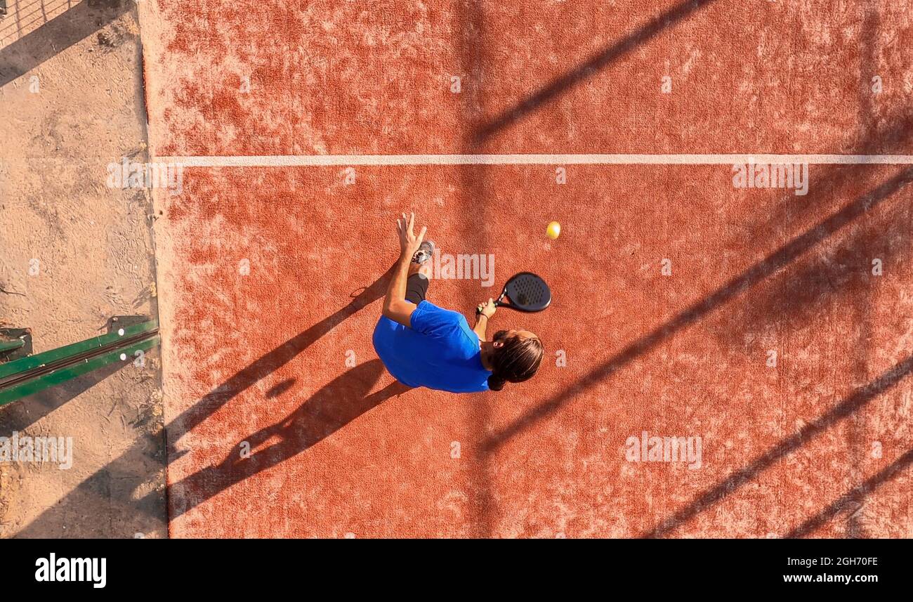 Top view of a man hitting a ball with the racket to practice paddle ...