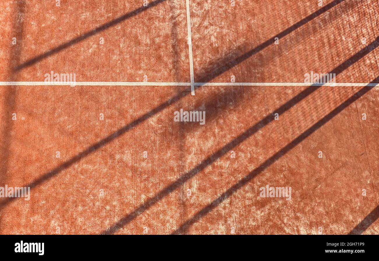 Texture of an outdoor paddle tennis court seen from above. Orange court ...