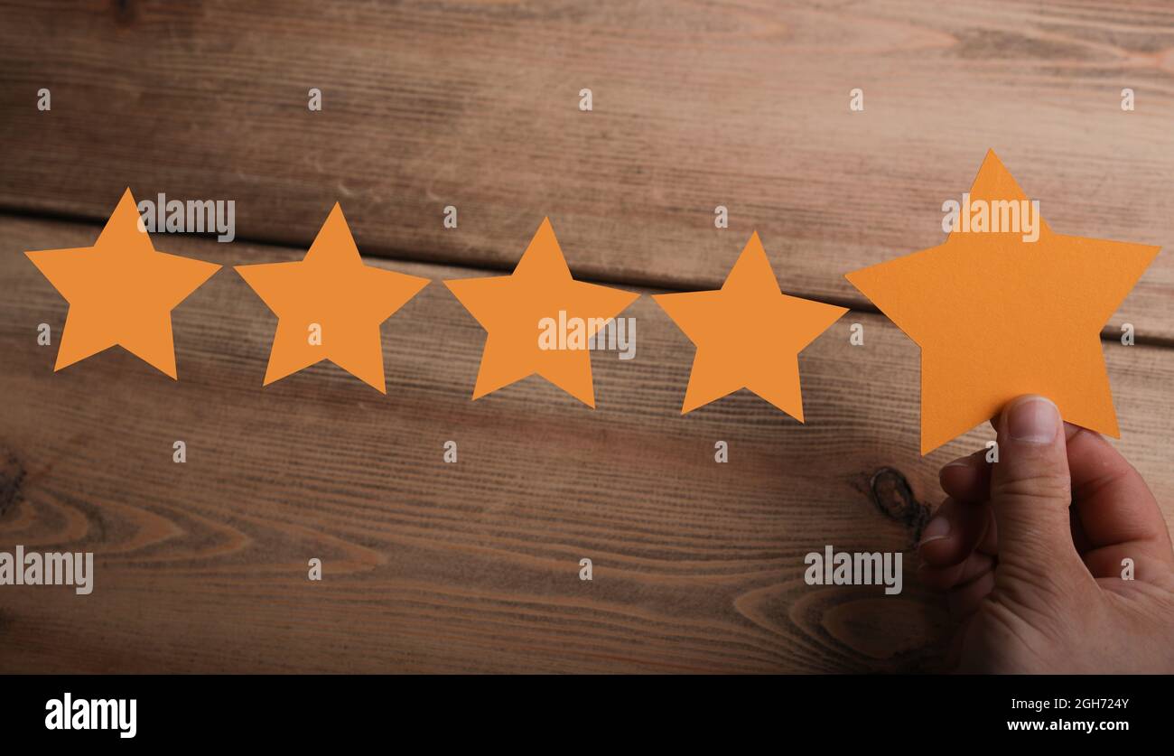 A concept of a ranking by giving stars, 5 stars on a wooden surface ...