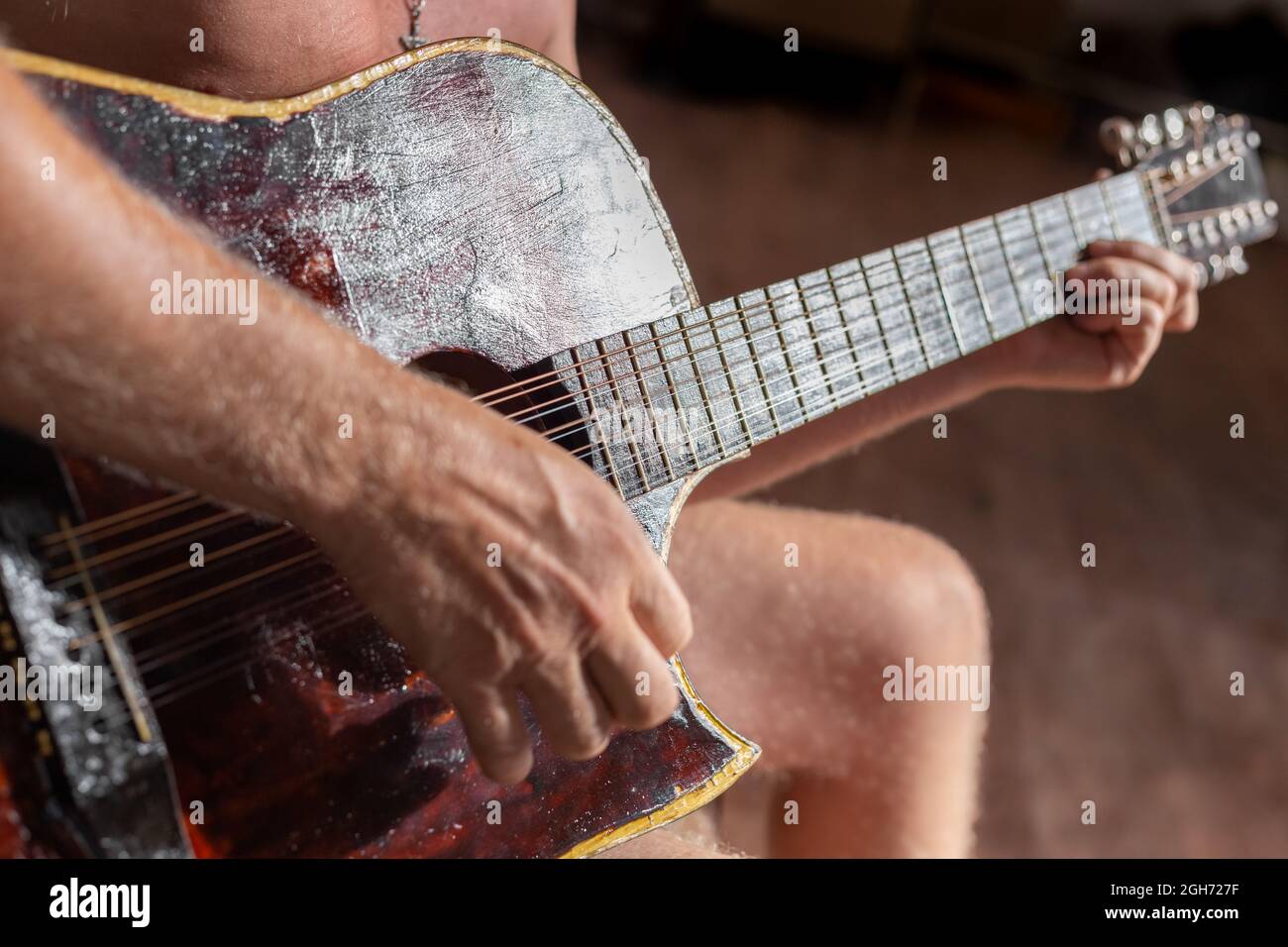 A man plays a twelve-string acoustic guitar. Hobbies and entertainment ...
