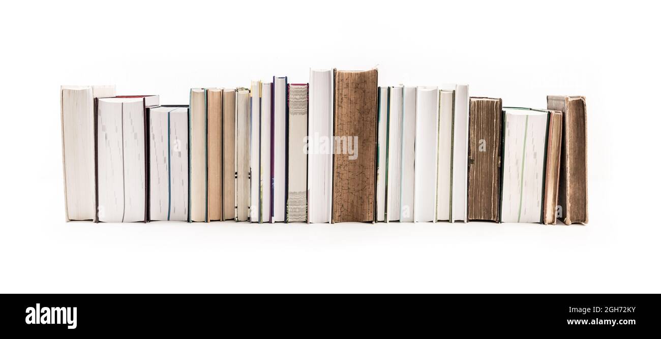 Assortment of new and old books in a row isolated on white background ...