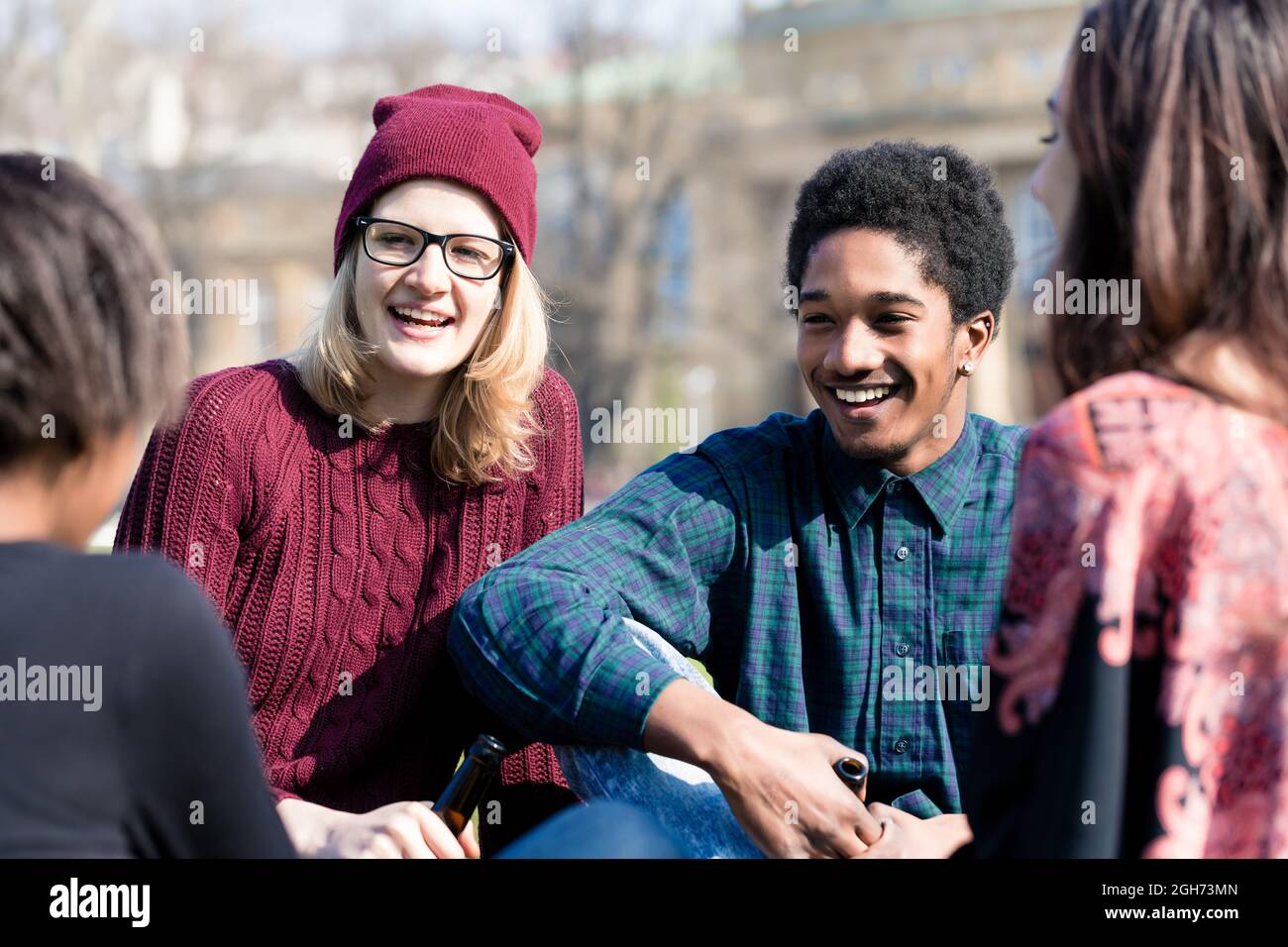 Diverse friends sitting together in the park Stock Photo - Alamy