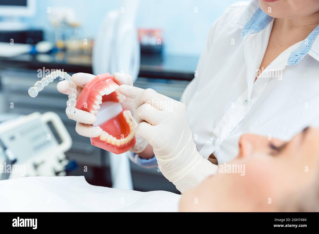 Dentist showing to female patient teeth dentures Stock Photo - Alamy