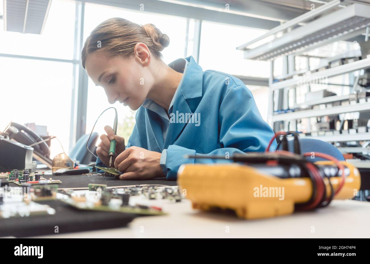 Worker in electronics manufacturing soldering a component for the ...