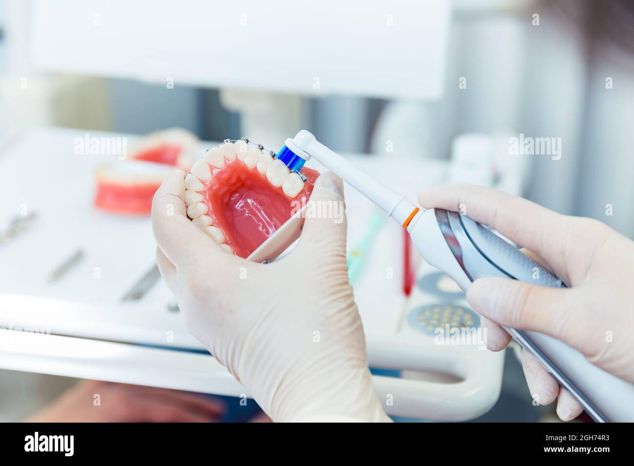 Dental doctor wearing gloves in hand showing how to brush your teeth ...