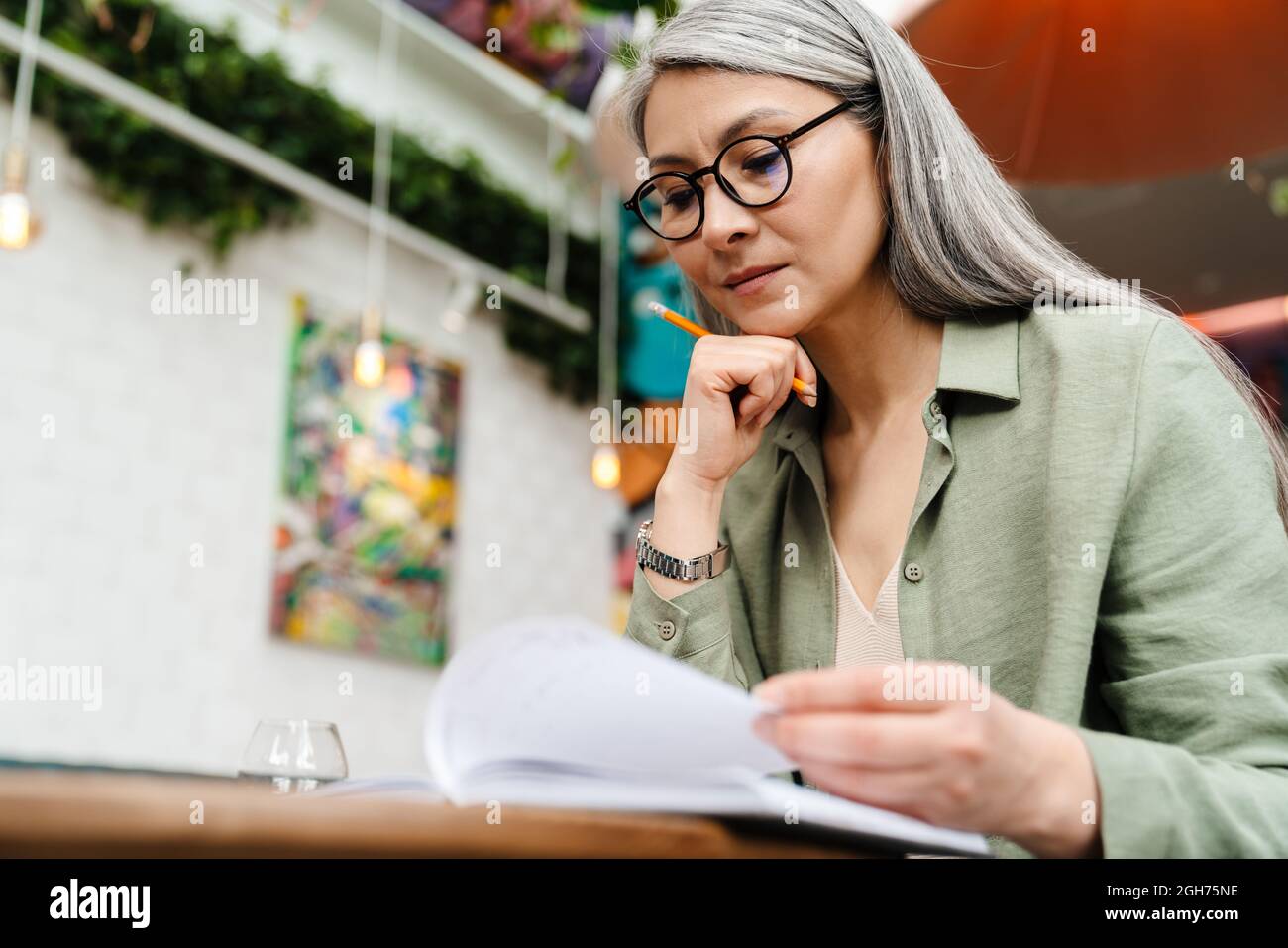 Mature grey thinking woman working with planner in cafe indoors Stock ...