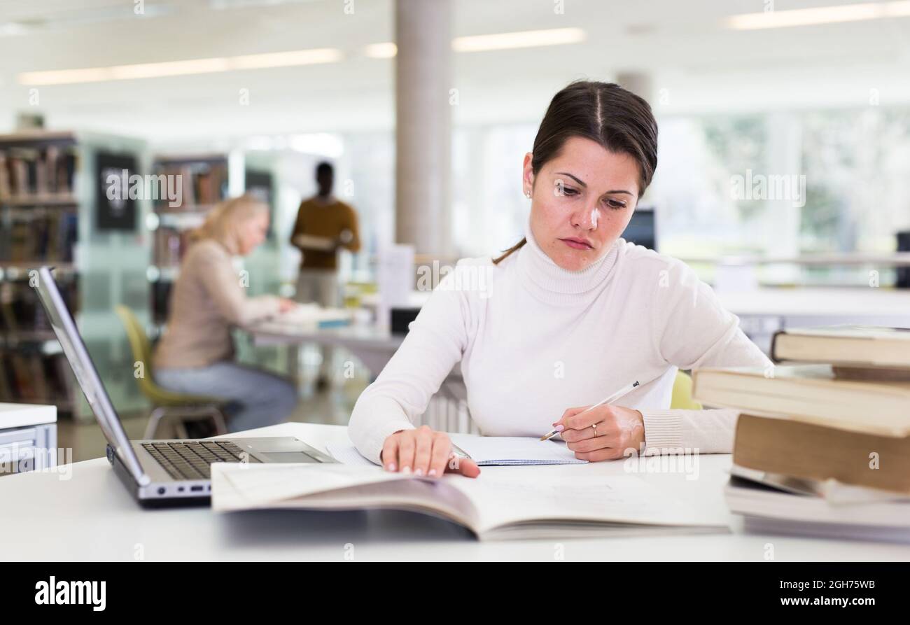 Successful woman studying in the library Stock Photo - Alamy