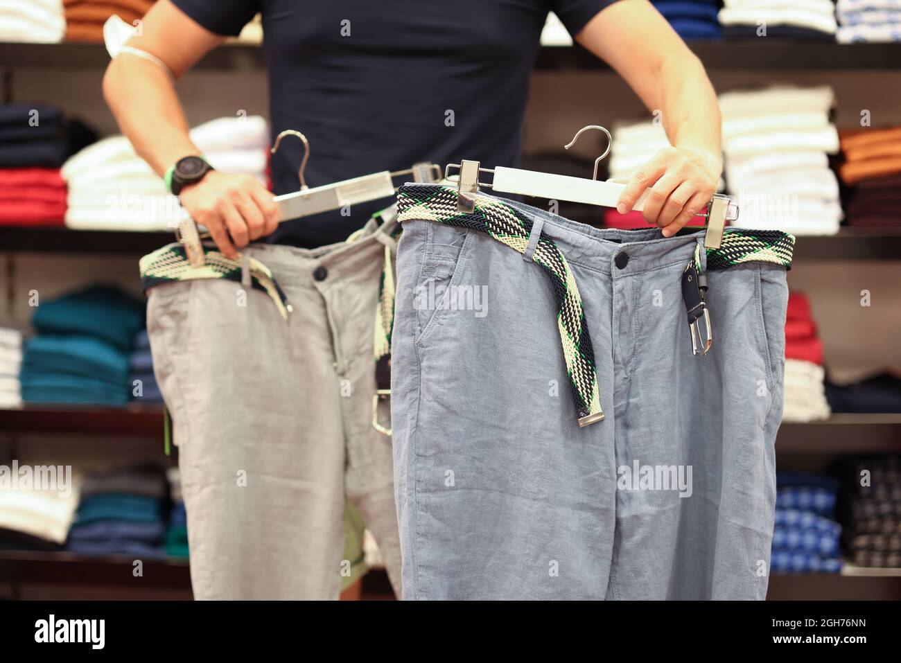 Shopping in men clothing store. Man chooses clothes in clothing store ...
