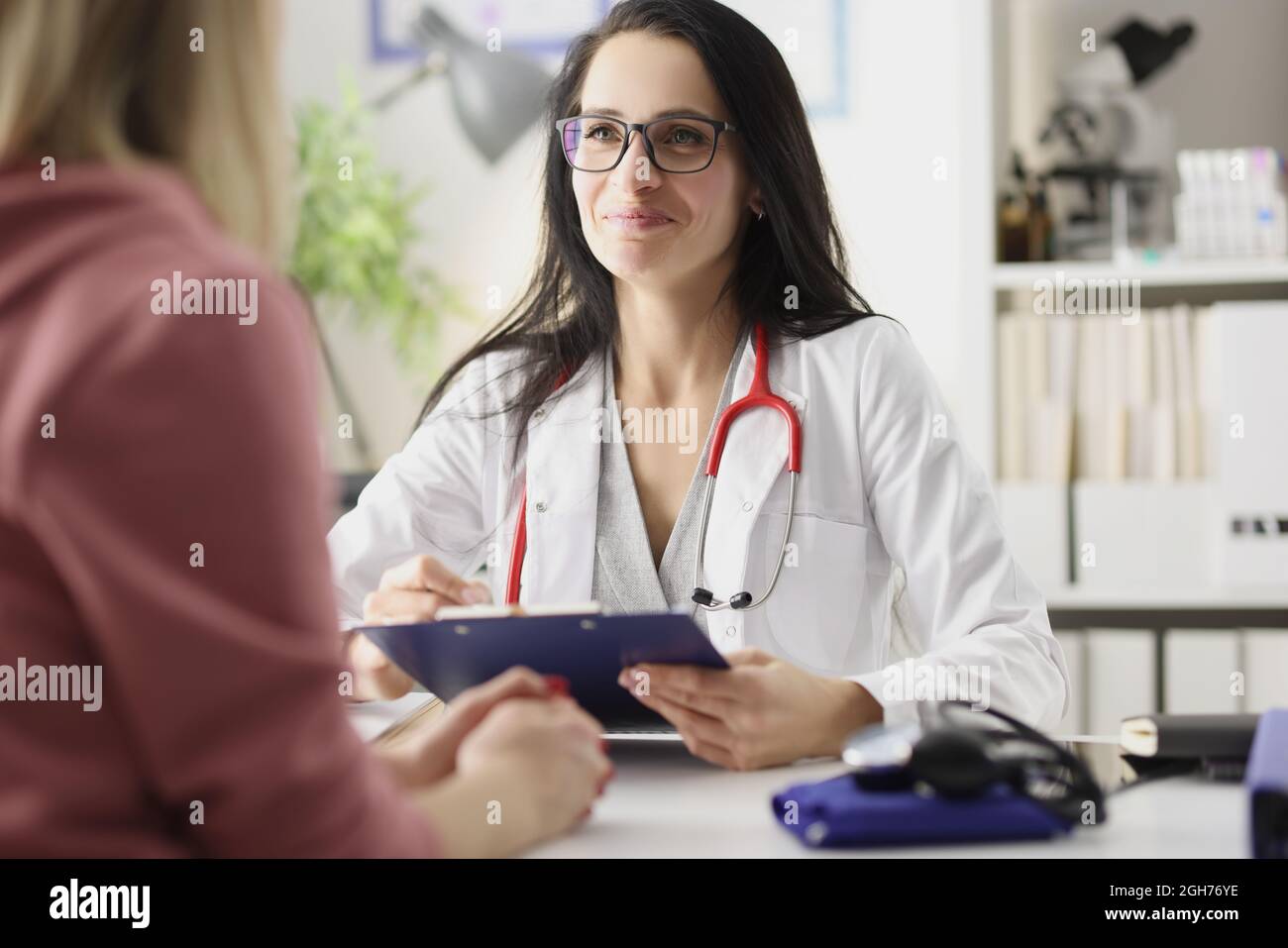 Happy smiling woman doctor is receiving patient at clinic Stock Photo ...