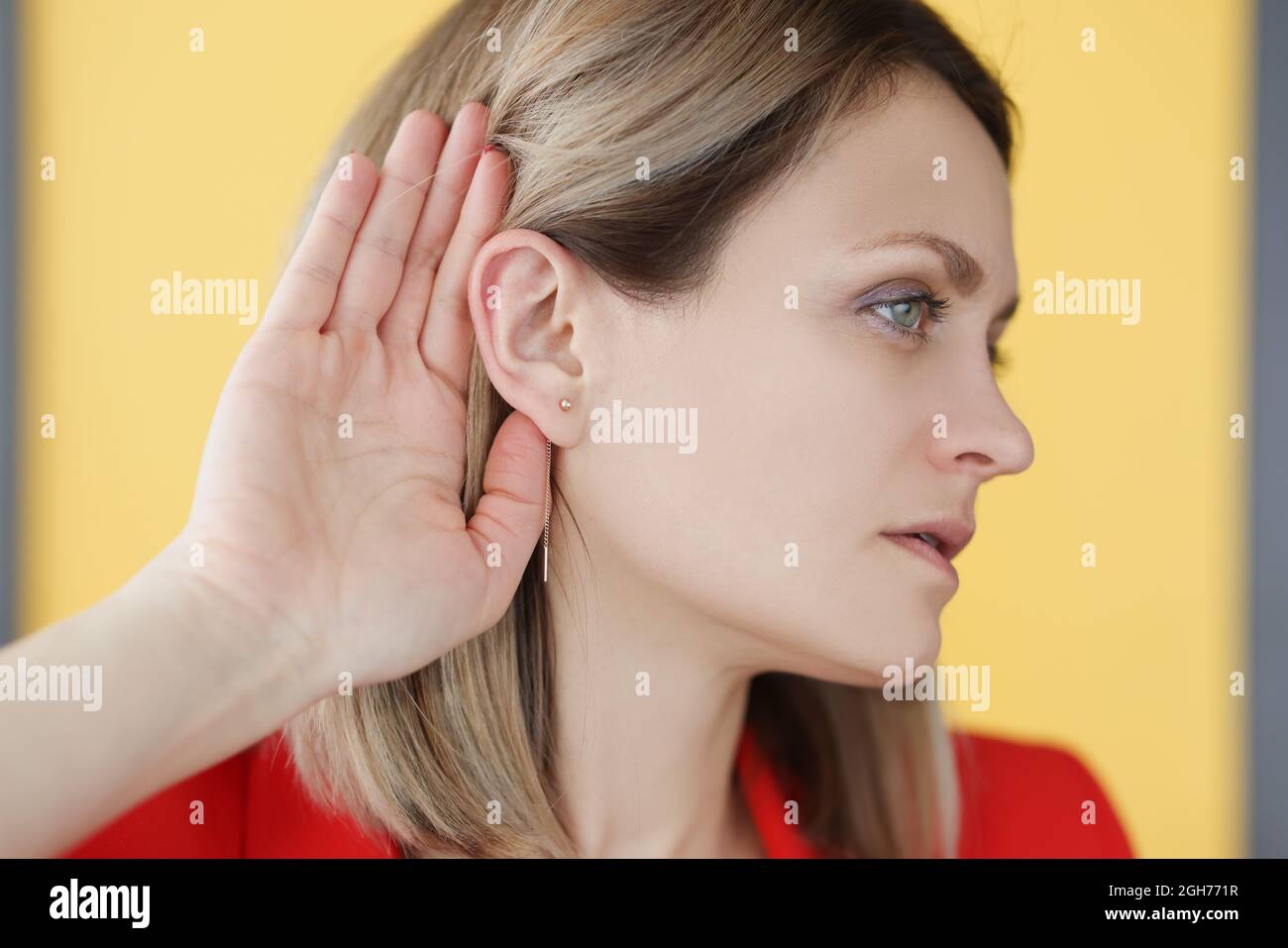 Deaf-mute woman holding her hand near ear Stock Photo - Alamy