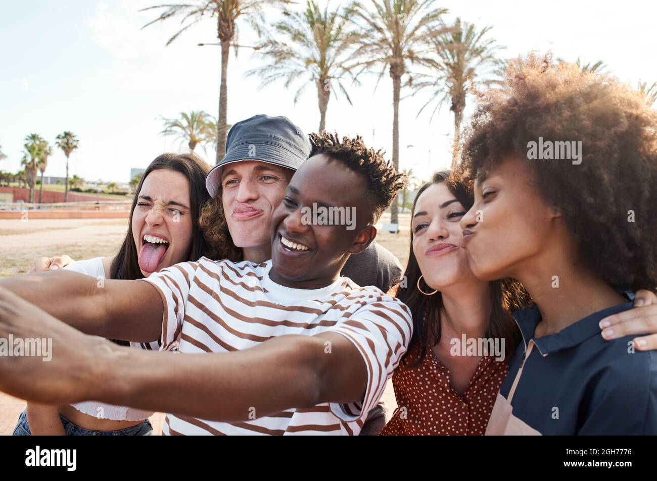 Young interracial friends take a picture playing fool. Group of people ...