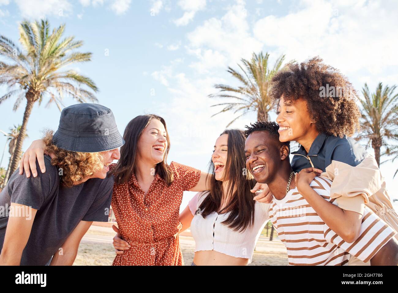 Group of young people laughing and having fun outside a beach town ...