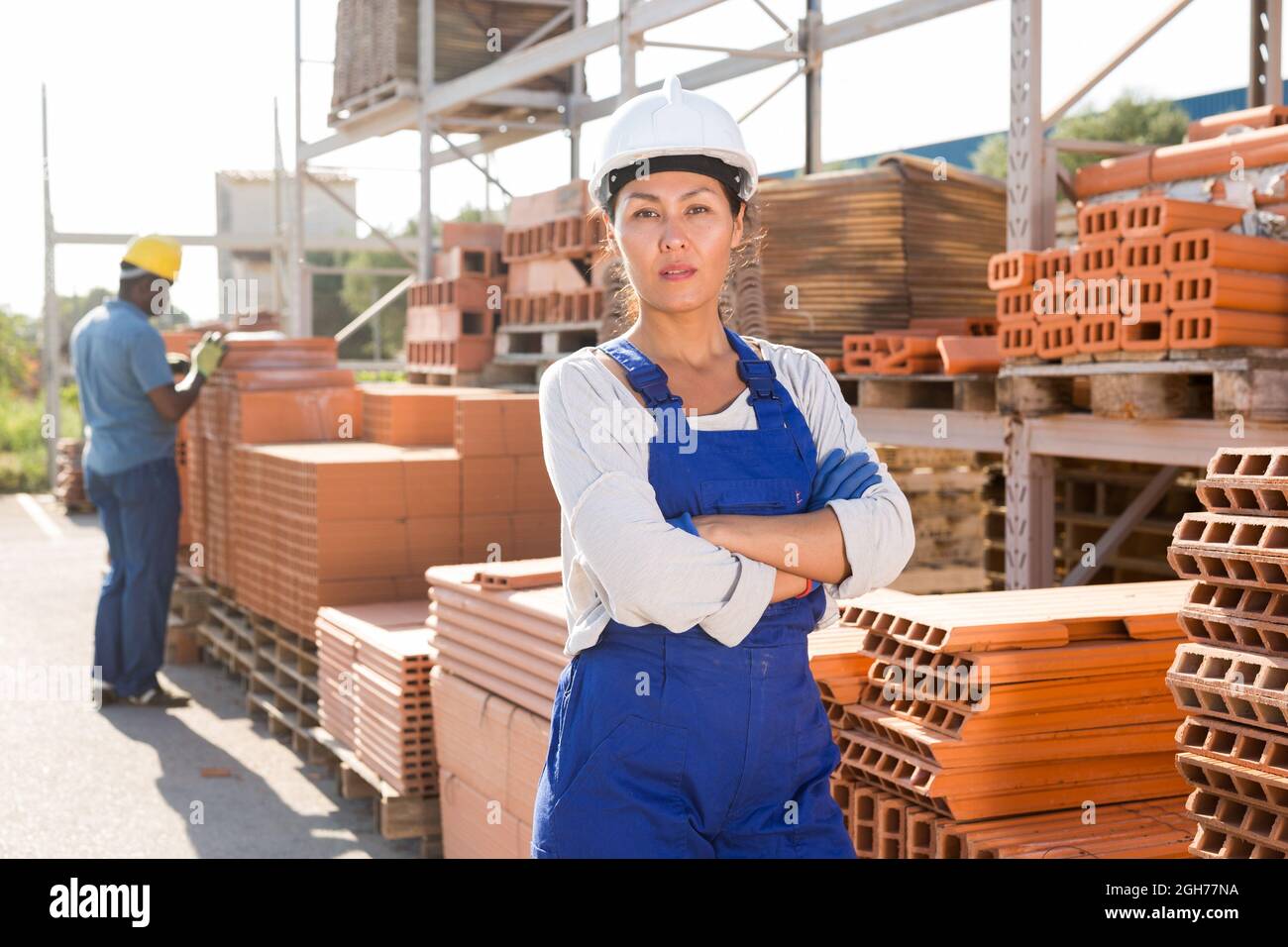 Portrait of female worker at warehouse of building materials in open ...