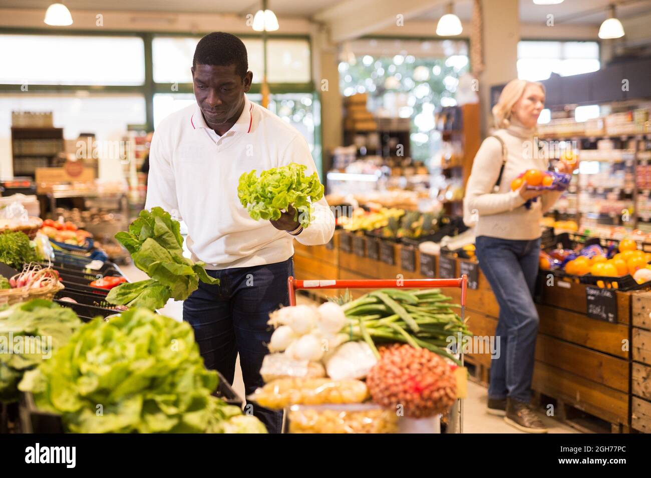Man choosing vegetables in store Stock Photo - Alamy