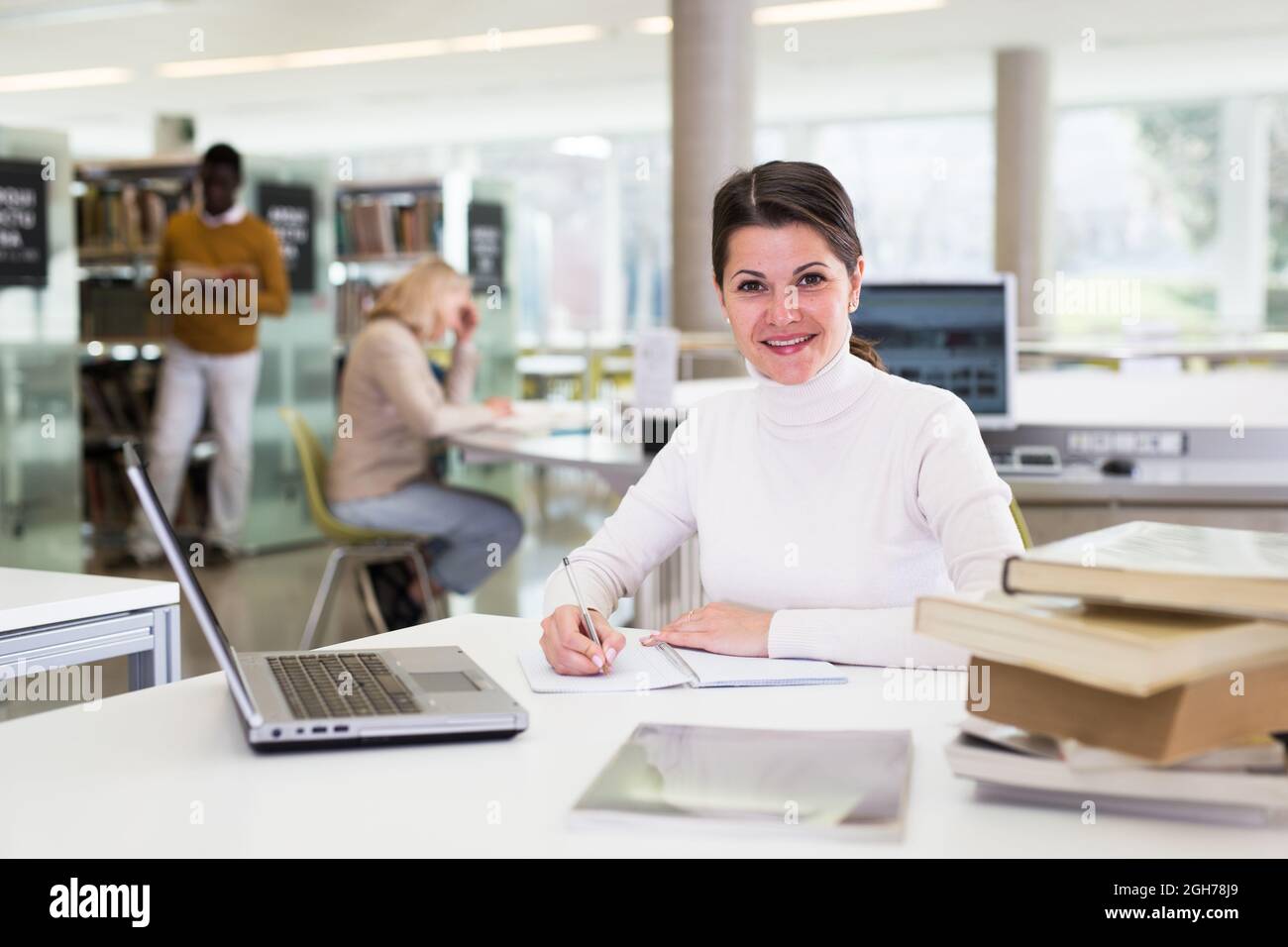 Successful woman studying in the library Stock Photo - Alamy