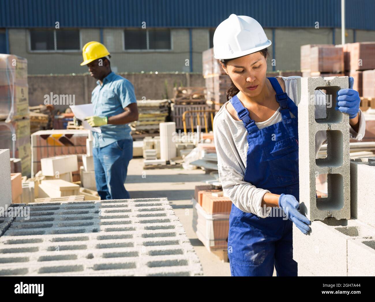 Asian worker stacking bricks in warehouse of building materials on an ...