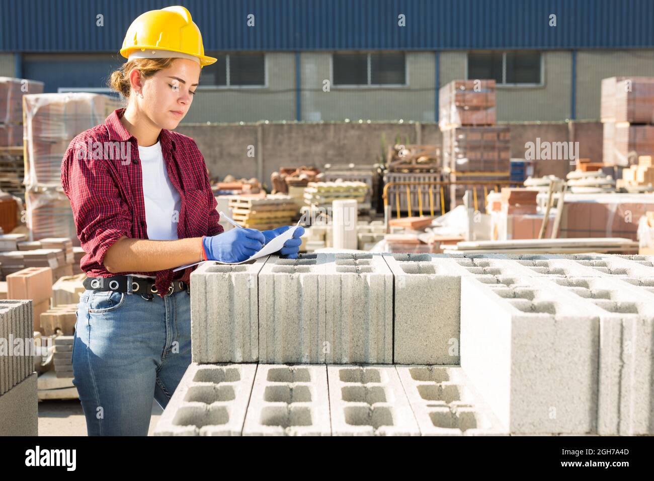 Young female worker filling documentation in outdoor warehouse Stock ...