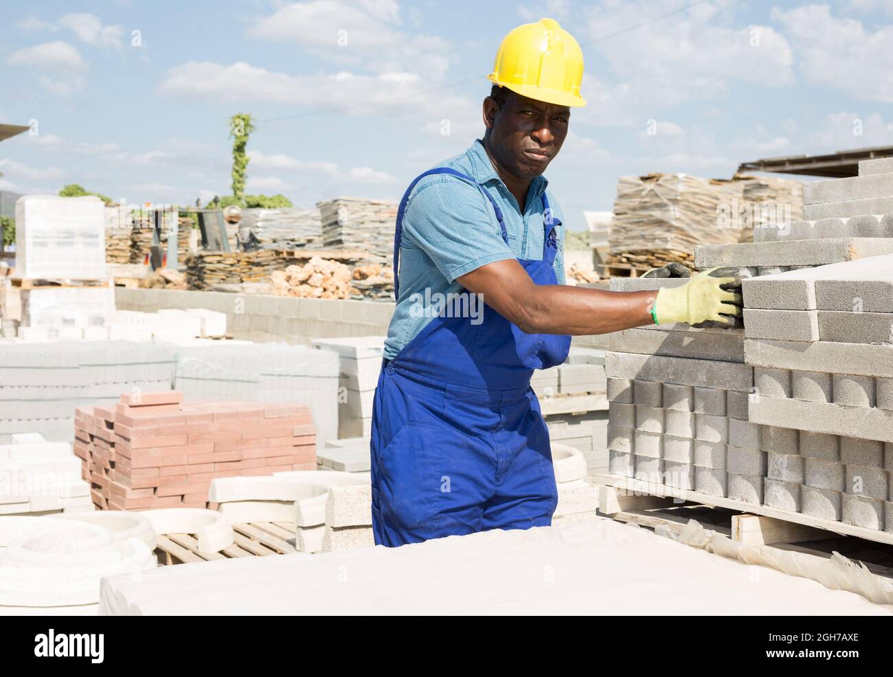 Worker stacking paving slabs in warehouse of building materials Stock ...