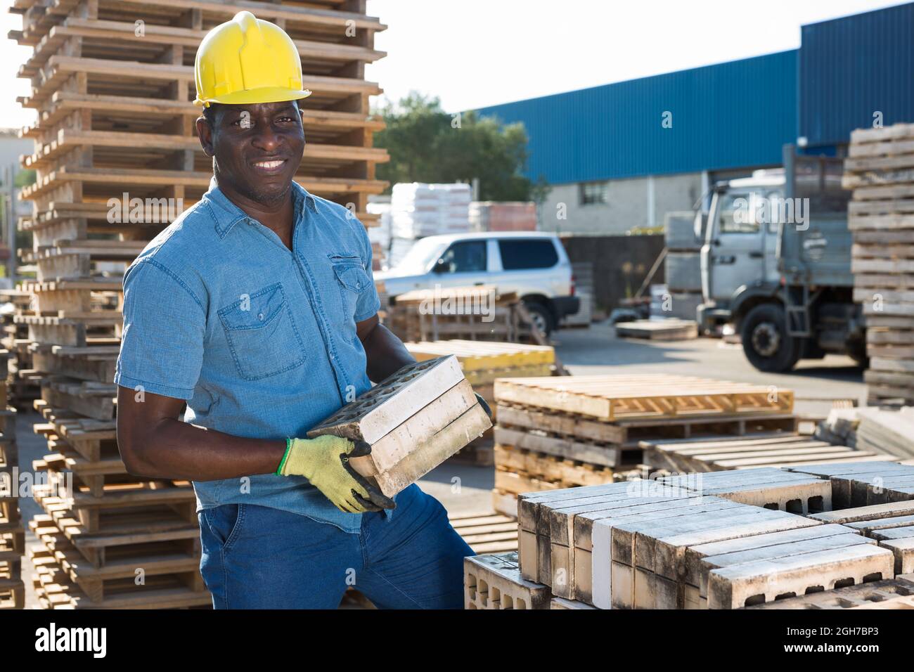 man is checking quality of bricks in the open area of a construction ...