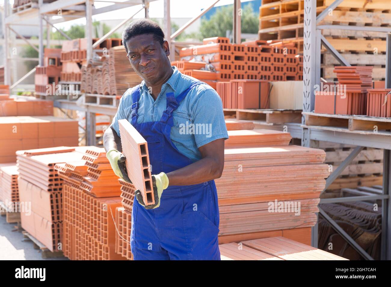 African american worker stacking bricks in warehouse of building ...