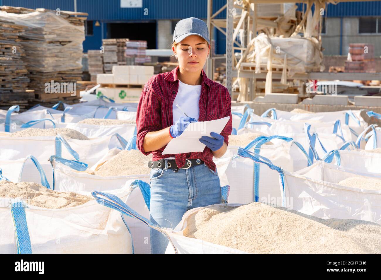 Female supervisor checking quality of building mix at store Stock Photo ...