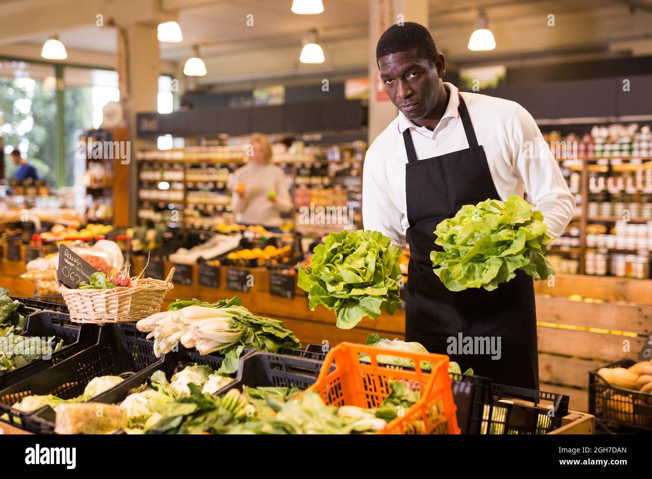 Salesman filling crates of vegetables Stock Photo - Alamy