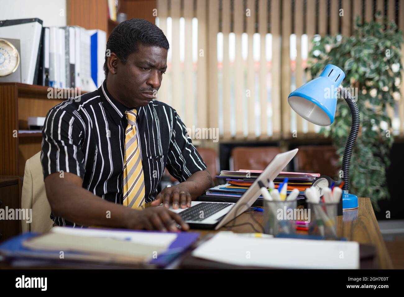 Focused african american man working at office desk Stock Photo - Alamy