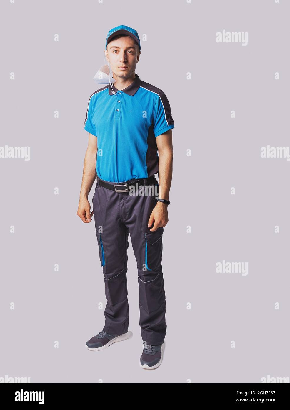 Full-length photo of a postman in a blue uniform and the cap wearing ...