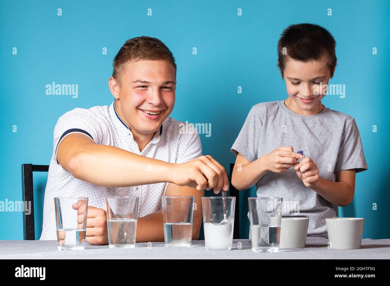 Chemistry education and study concept. Dad and her son stirs measuring ...