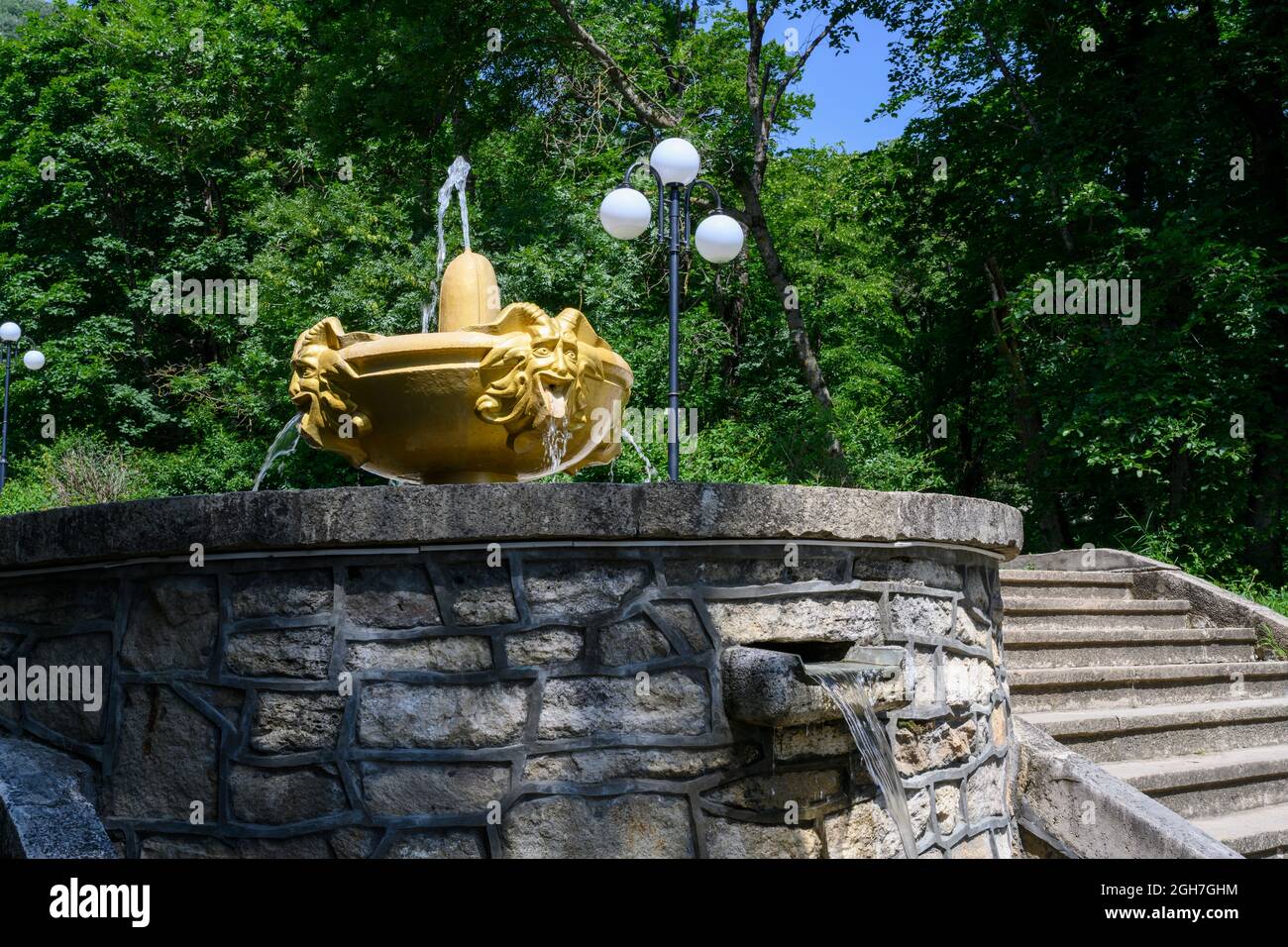 Fountain with the heads of gilded goats in a park in the city of ...
