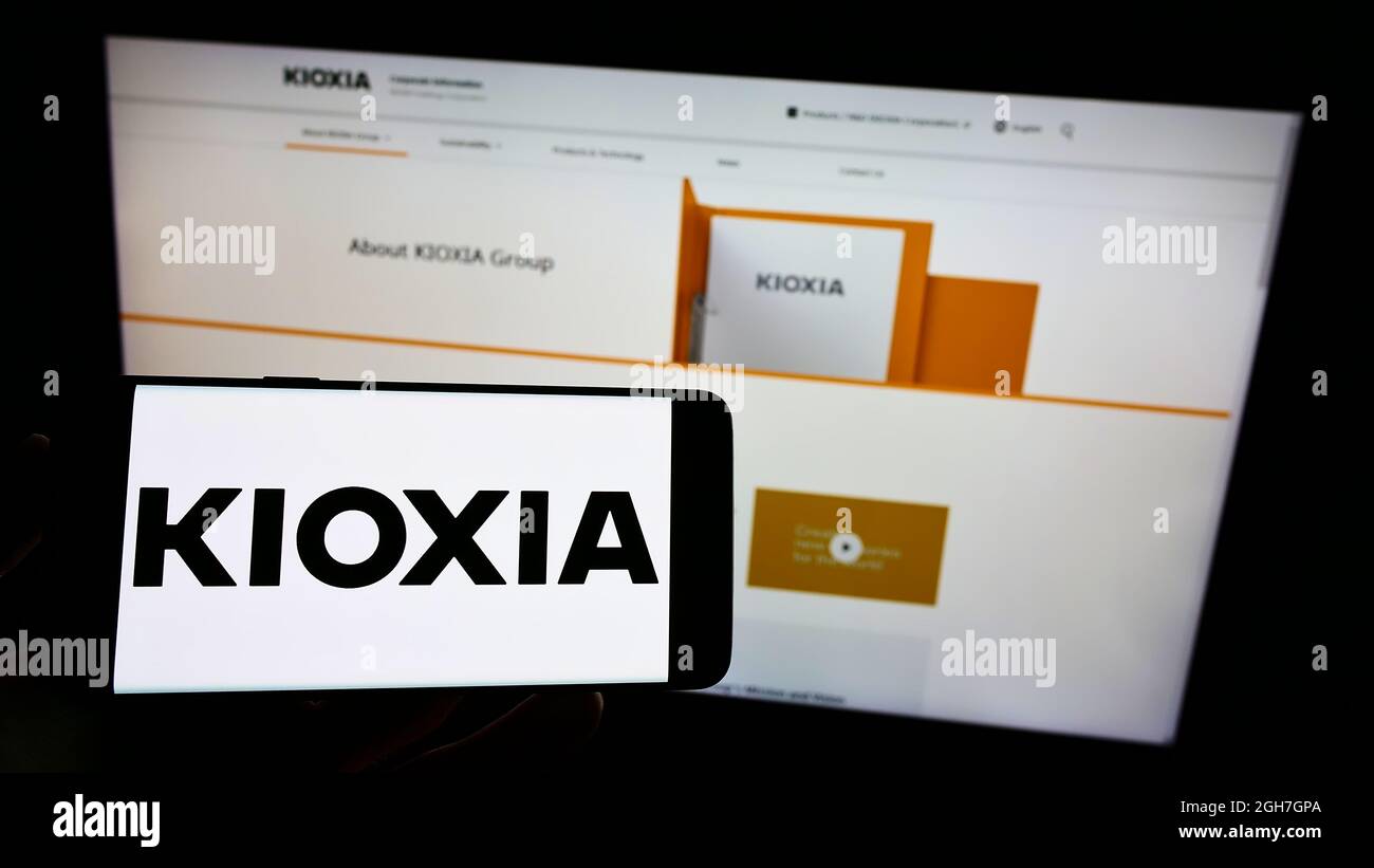 Person holding mobile phone with logo of Japanese company Kioxia ...