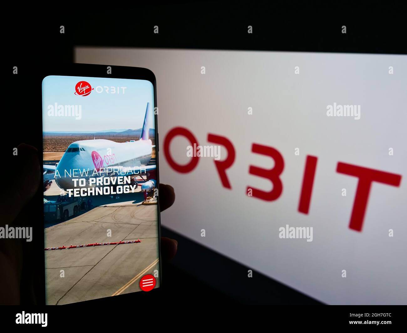 Person holding cellphone with webpage of US aerospace company Virgin ...