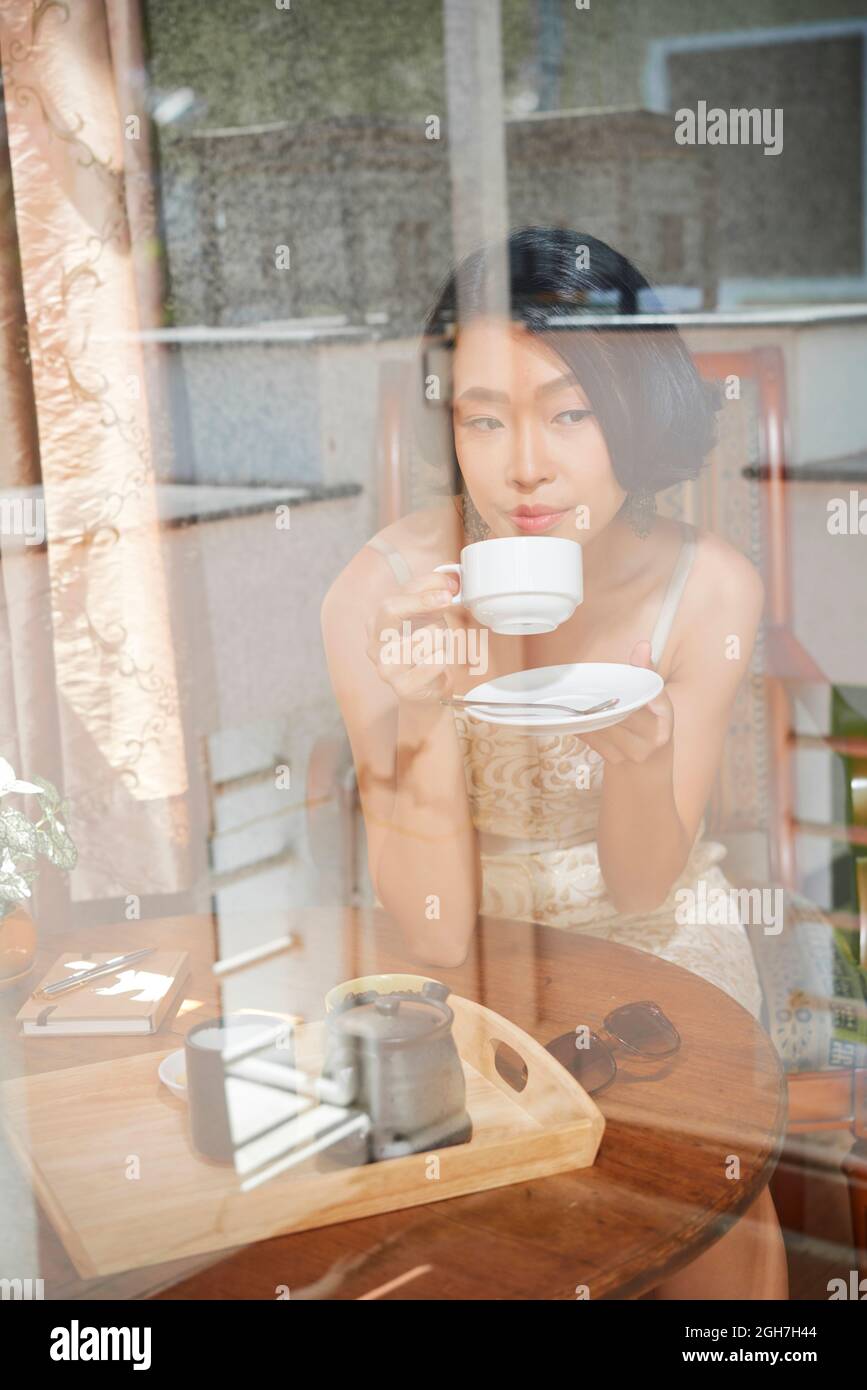 Glamorous elegant young woman enjoying cup of tea in fancy restaurant ...