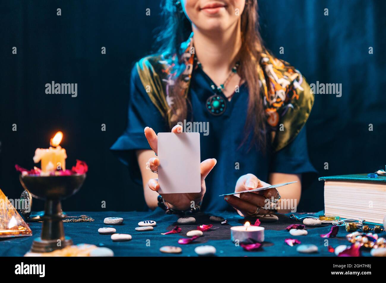 Magic and esotirism concept. Smiling fortune-teller shows an empty ...