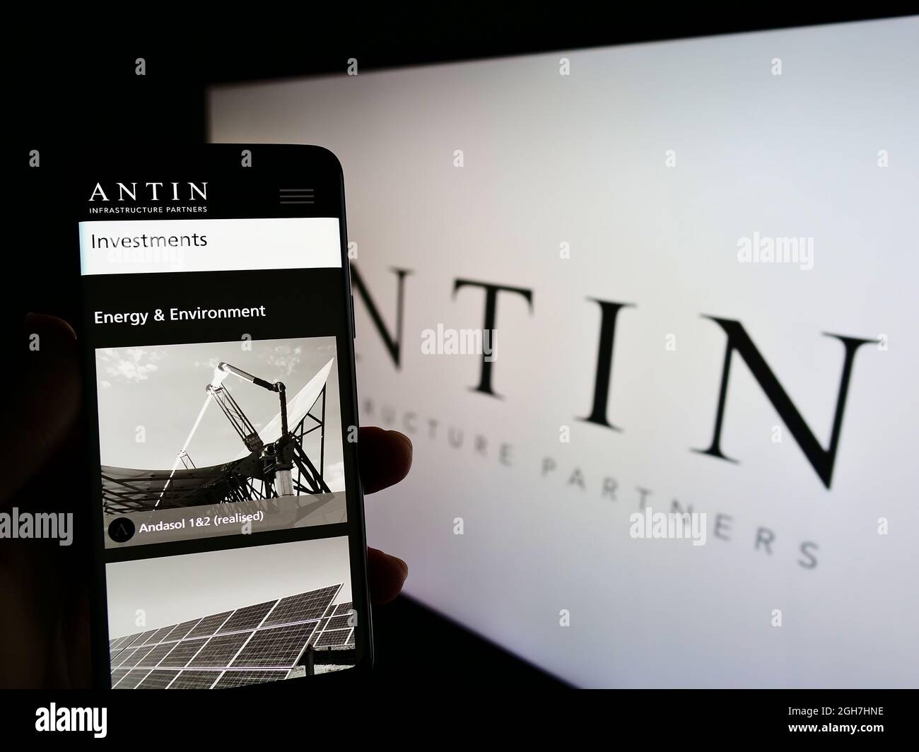 Person holding cellphone with webpage of investment company Antin ...